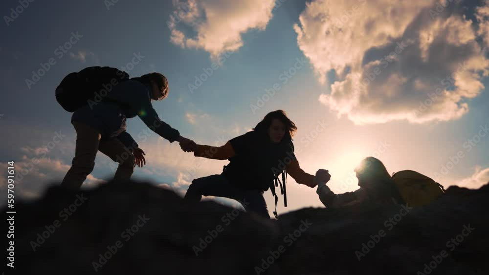 Helping hand in teamwork.Group of climbers daring climb to victory ...