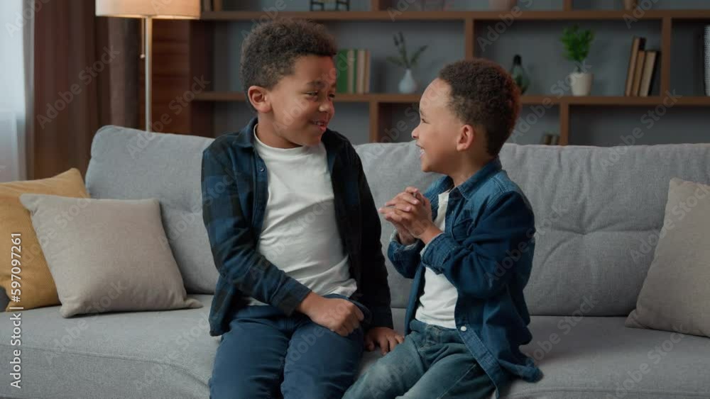 Two little boys brothers children kids siblings at home couch talking ...