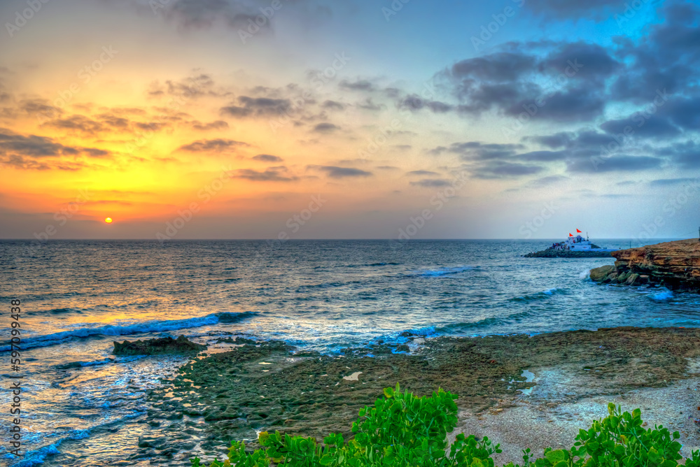 Beautiful sunset and Bhadkeshwar Mahadev temple on the sea shore of ...