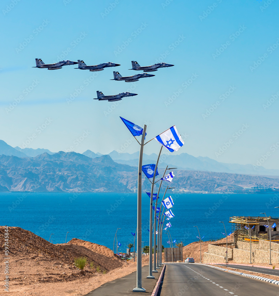 Israeli flags and modern militaristic fighters, above Eilat city and ...