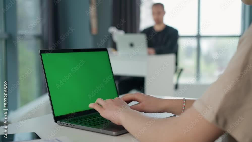 Young Woman Uses Laptop with Green Mock-up Screen In Office. Business ...