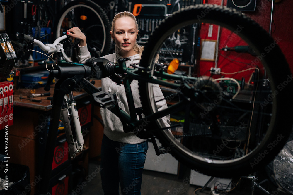 Professional blonde cycling mechanic female watching rear shifter of ...