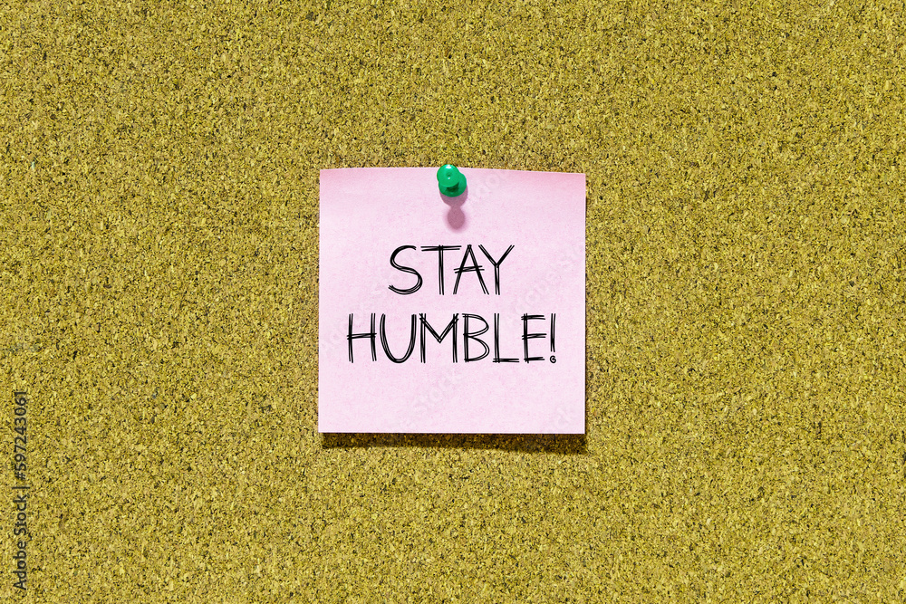 Stay humble text on pink post-it paper pinned on bulletin cork board ...
