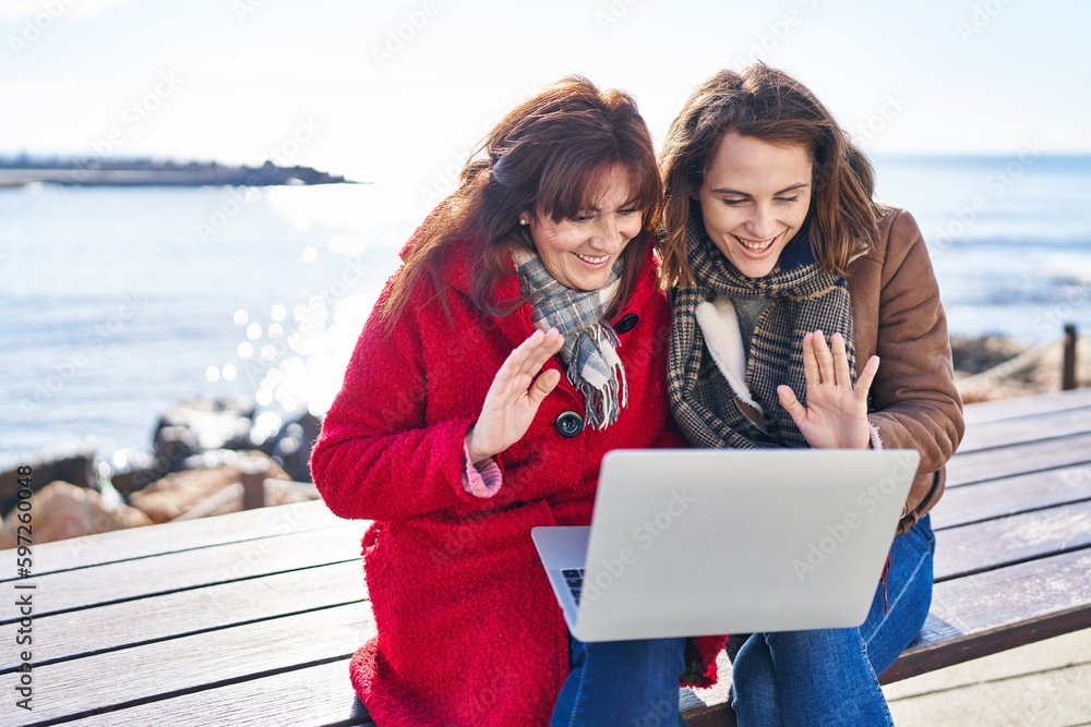 Two women mother and daughter having video call sitting on bench at ...