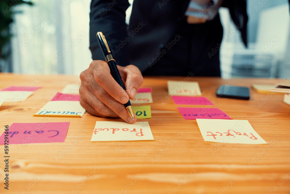 Businessman brainstorming and writing creative idea on colorful post-it ...