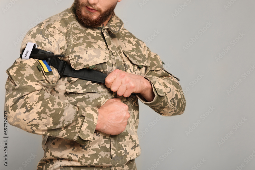 Ukrainian soldier in military uniform applying medical tourniquet on ...