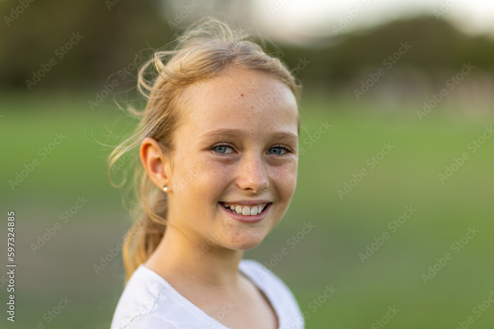 Head And Shoulders Of Blonde Ten Year Old Girl Smiling And Looking At