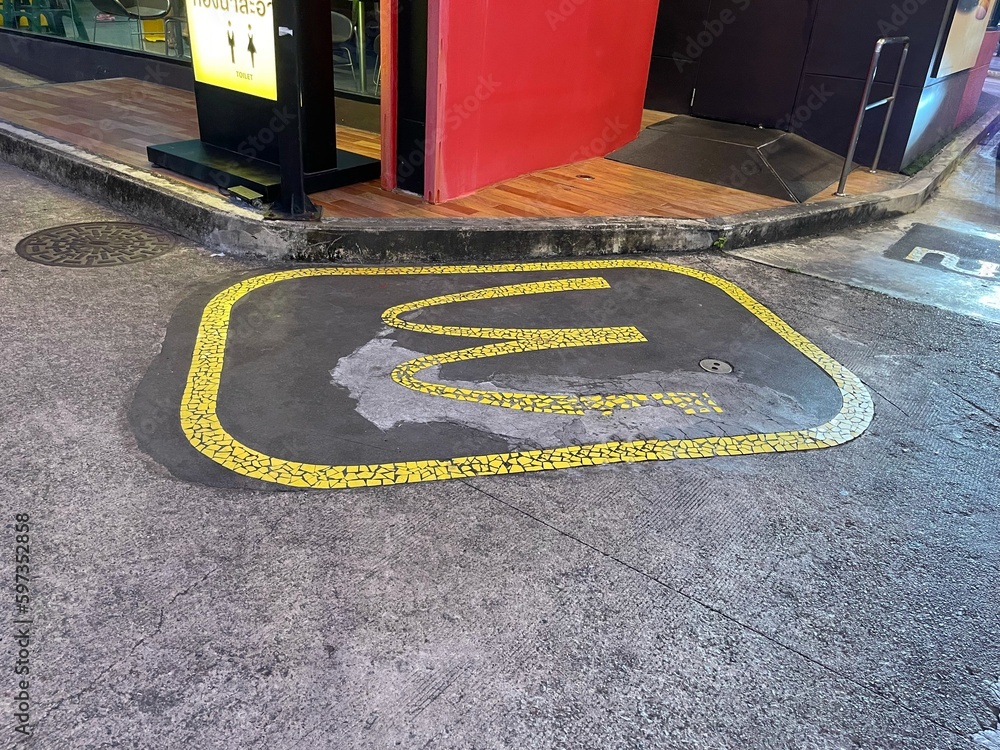 McDonald's sign, logo with two yellow arches are paved with small tiles ...