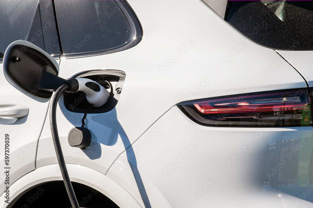 Electric car connected to EV charging station with EV charging cable ...