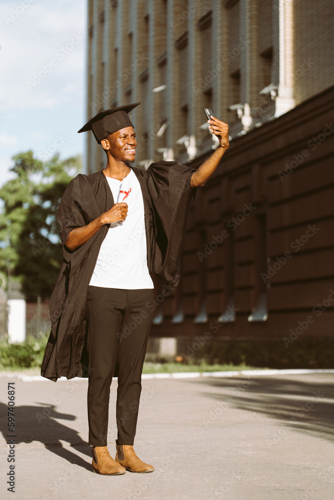 Smiling african american graduate from university taking photo with ...