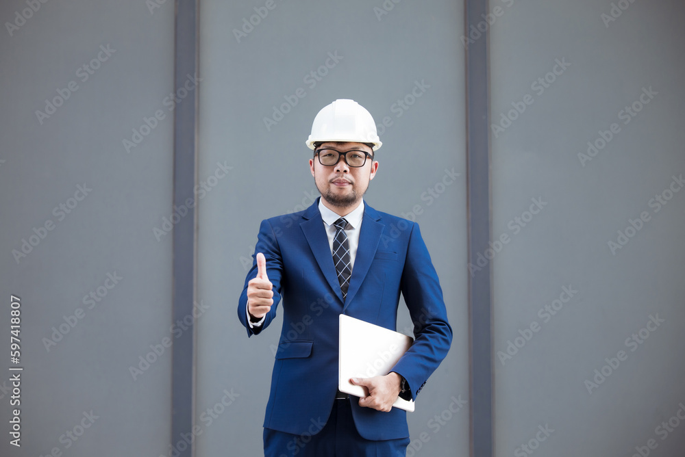 Handsome engineer wearing suit and hard hat or white helmet on building ...