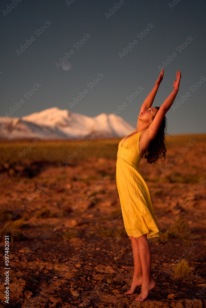 artistic full length portrait young woman with arms up trying to reach ...