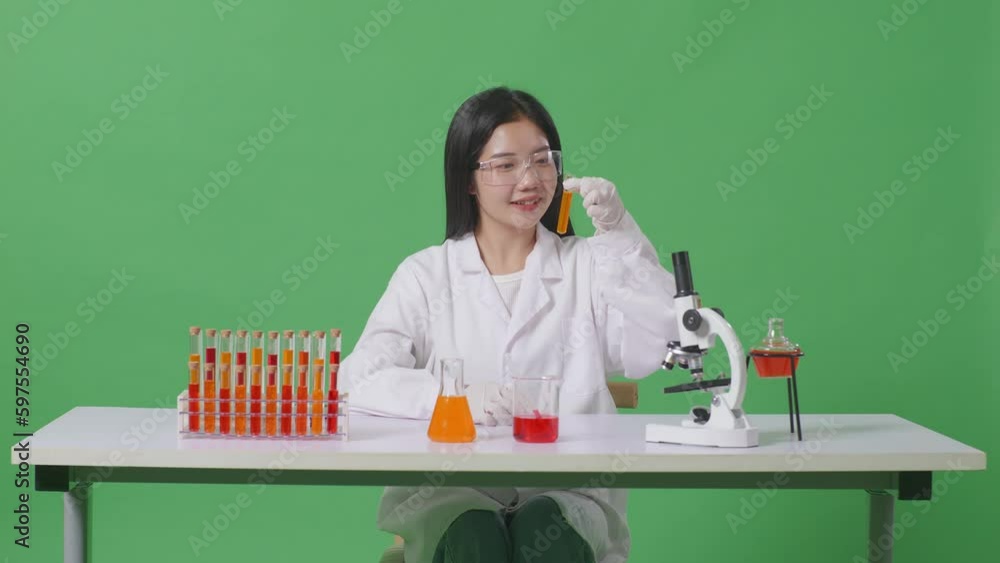 Asian Woman Scientist Looking Through A Microscope On The Table With ...