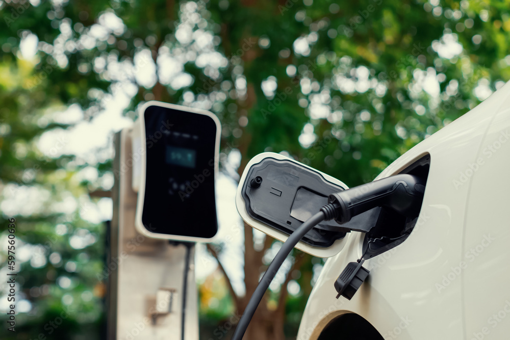 Focus closeup electric vehicle plugged in with EV charger device from ...