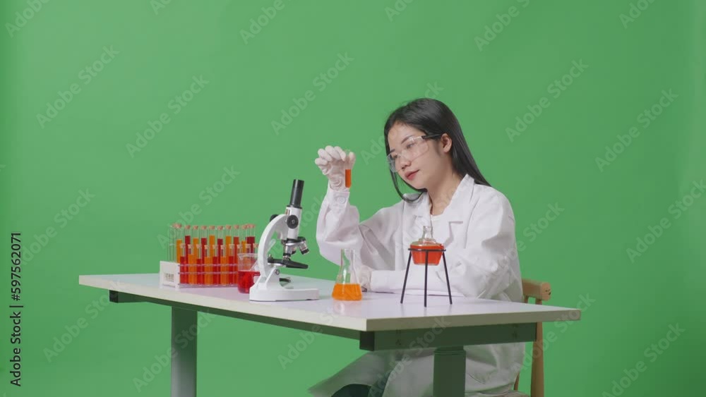 Side View Of Asian Woman Scientist Looking At The Orange Liquid In The ...