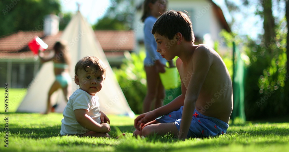 Child brother caring to younger baby infant sibling outside. Authentic ...