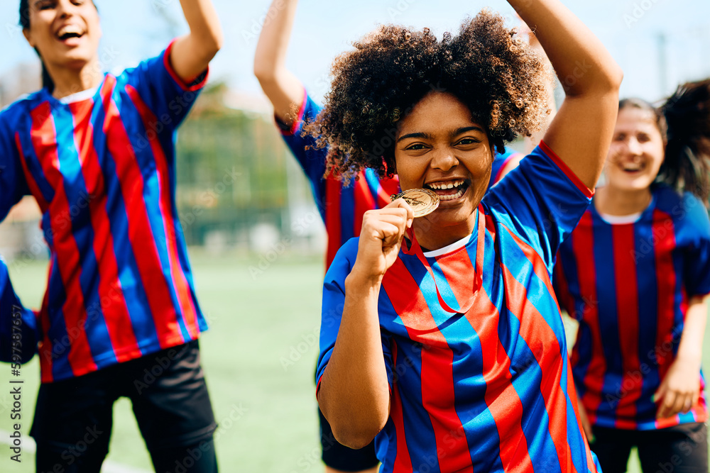 Happy African American player celebrating with her teammates winning ...