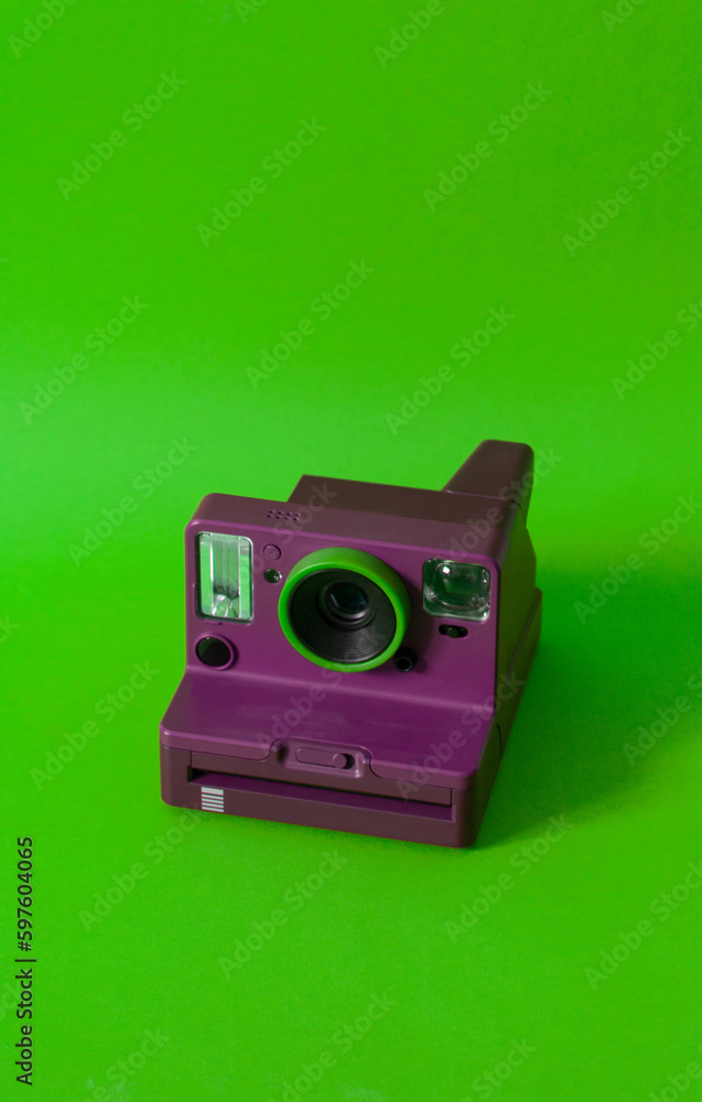 Cámara retro instantánea morada sobre fondo color verde. Fotografía de ...