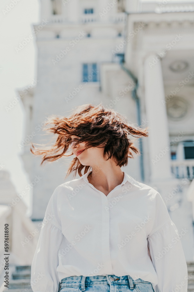 Wind hair style. A portrait of a woman outdoors, her shoulder-length ...