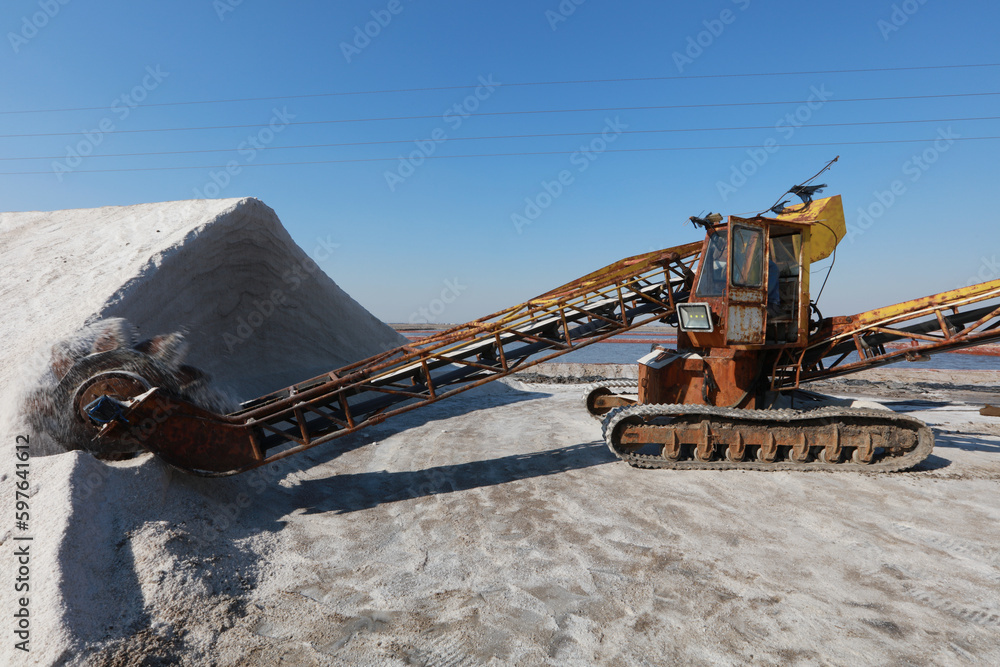 machine placing the harvested and washed salt on a conveyor belt. Salt ...