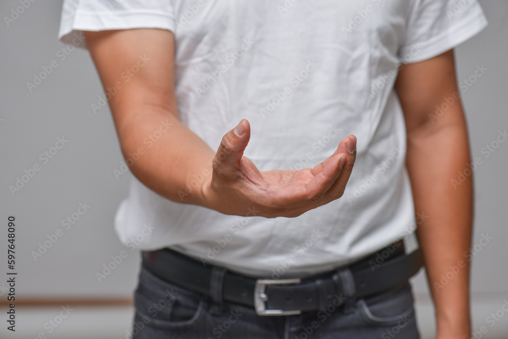 A man wearing a white shirt makes a hand signal to show a request for ...
