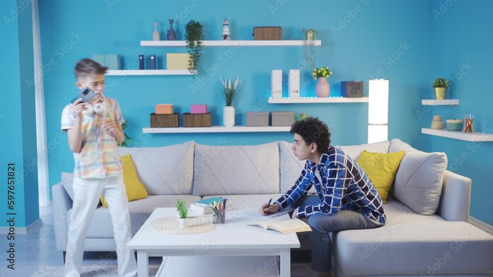 Vidéo Stock Little boy listening to loud music annoys his older brother ...