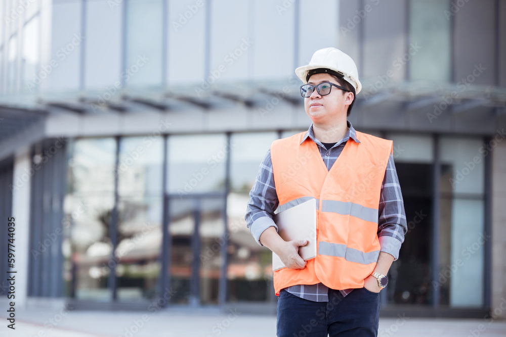 Handsome engineer wearing safety vest and white hard hat on building ...