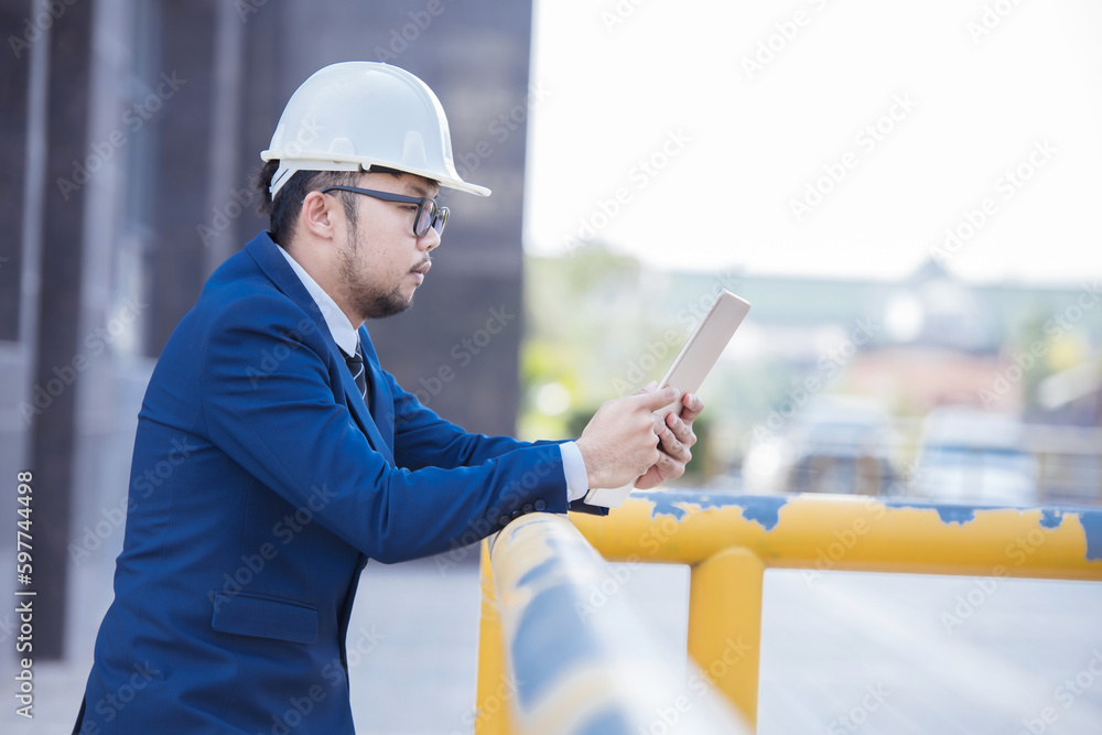 Handsome engineer wearing suit and hard hat or white helmet on building ...