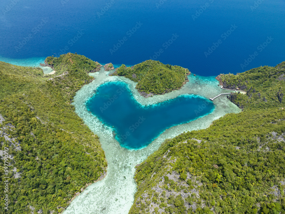 A heart-shaped lagoon is surrounded by dramatic limestone islands that ...