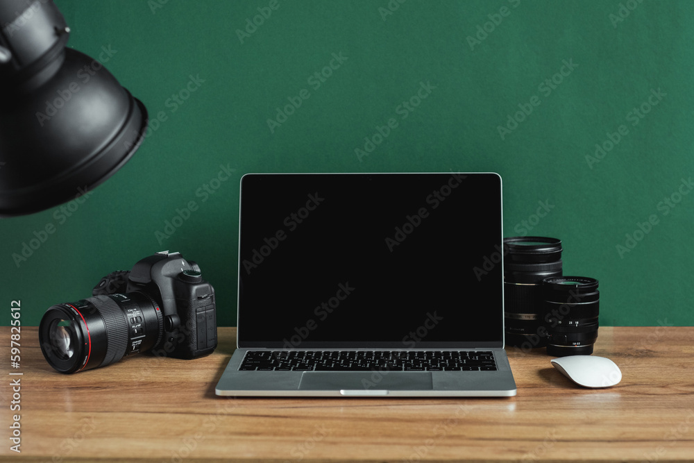 Modern photographer workplace with computer, DSLR camera and lenses ...
