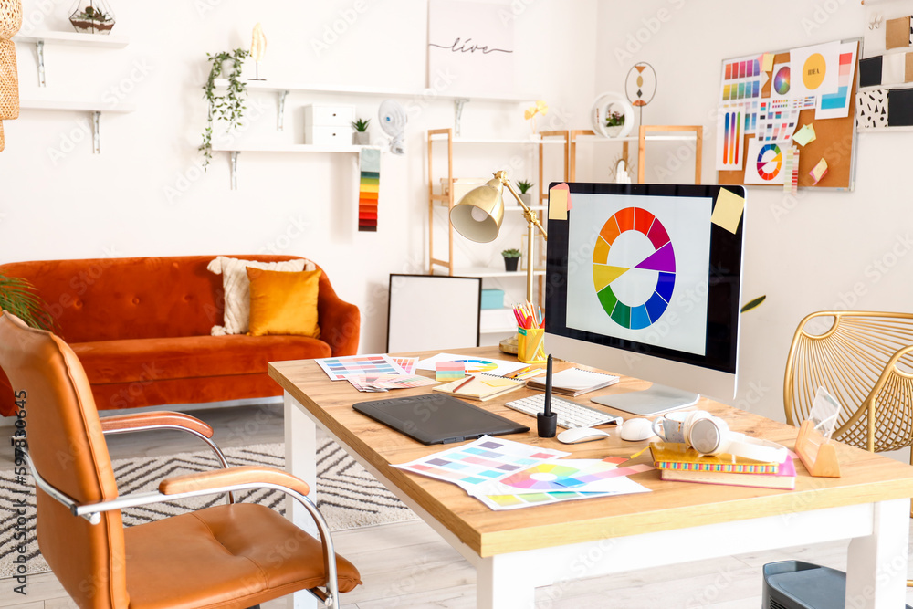 Graphic designer's workplace with computer, tablet and color palettes ...