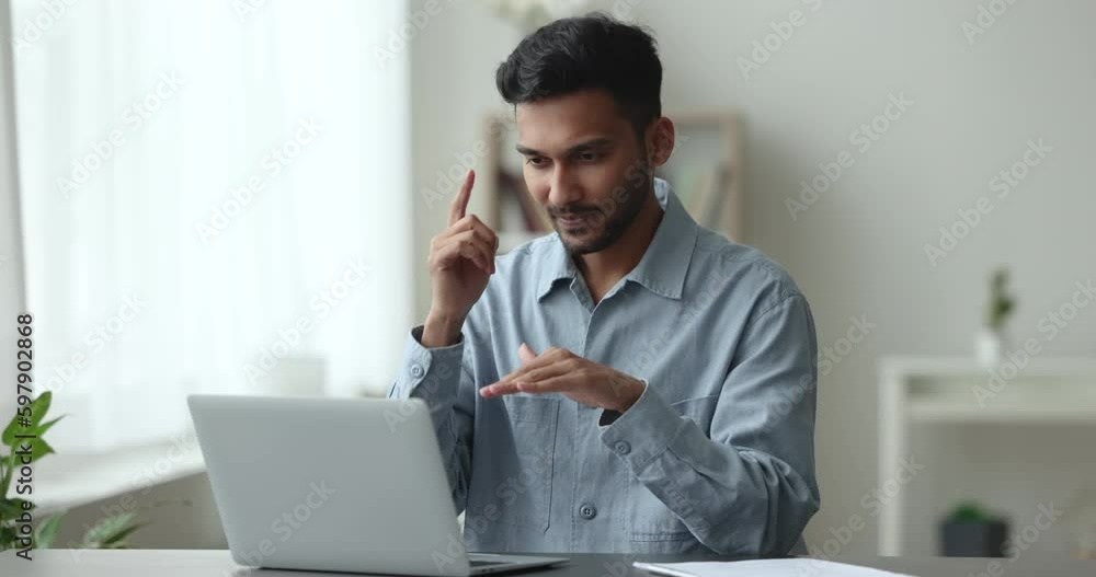 Indian deaf guy communicates with sign language sit at desk with laptop ...