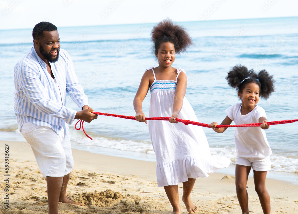Black family having fun on the beach. mixed race family competing in ...