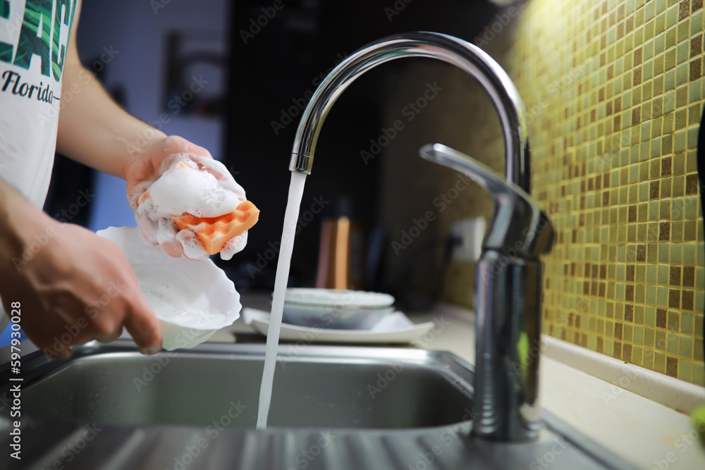 Man washing dish in sink at restaurant.People are washing the dishes ...