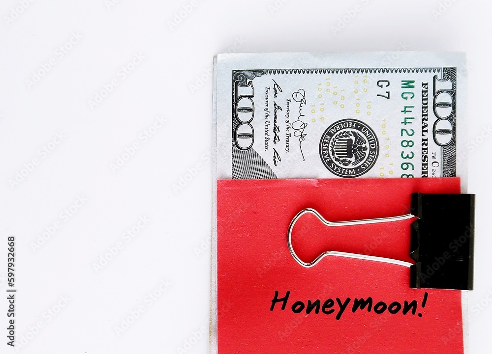 Cash money in dollars clipped with a red note written HONEYMOON on ...