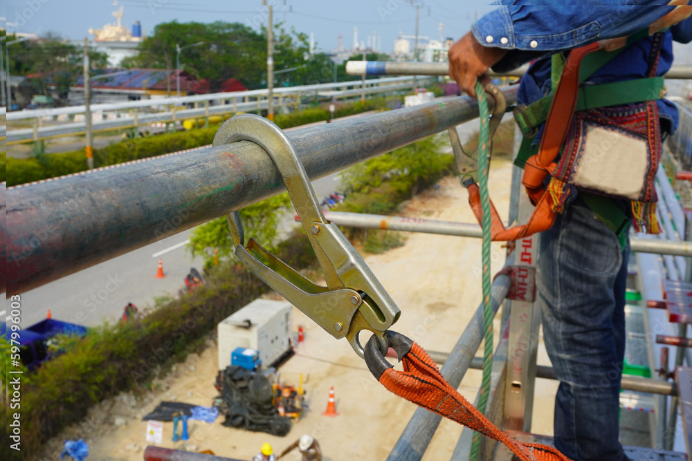 Hook of safety harness on scaffolding pipe during working at heights in ...