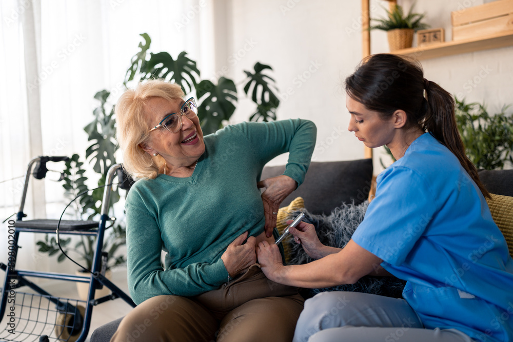 Nurse giving insulin injection to diabetic senior woman. Young ...