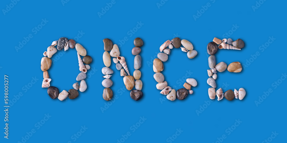 Fotka „The word "ONCE" is lined with sea shells and stones of various ...