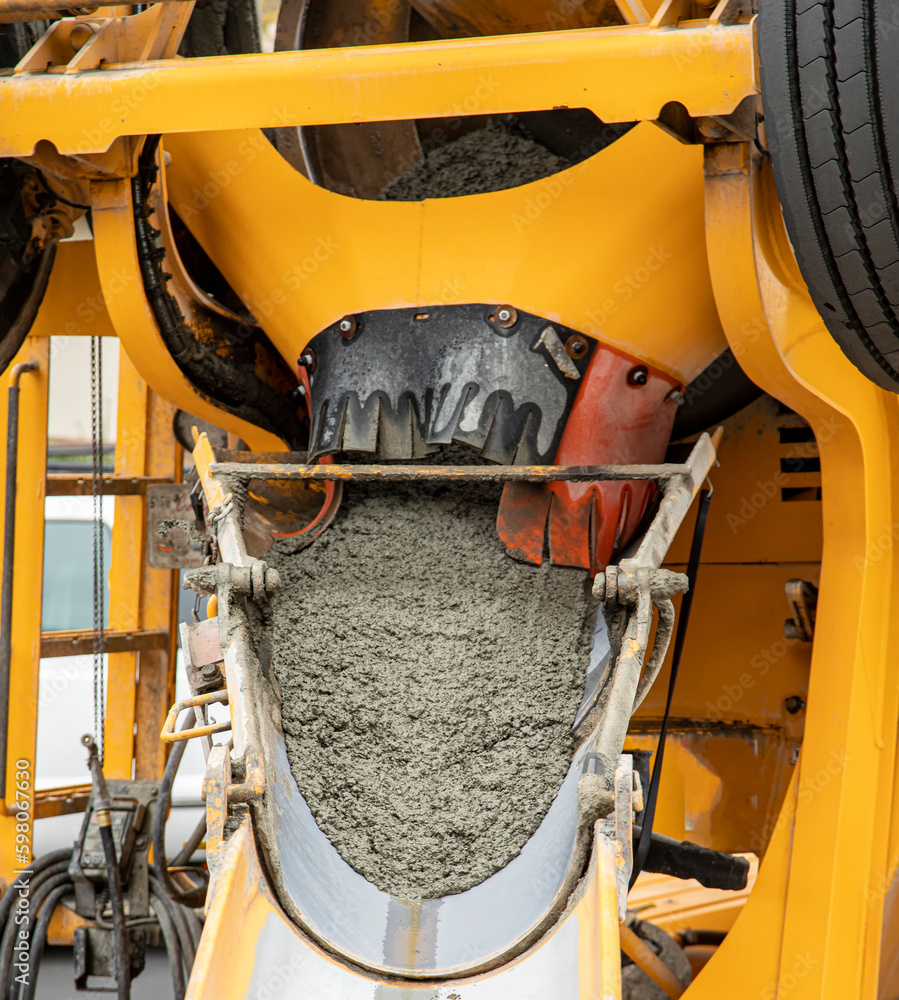 Wet Cement coming down a cement truck chute at a construction site ...