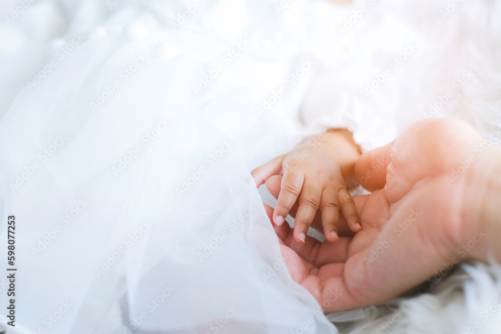 Closed up of baby little hand touching her mom hand gentlely in heart ...