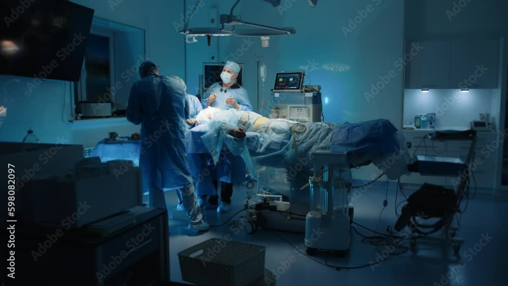 Long shot of plastic surgery procedure, patient lying under anaesthetic ...