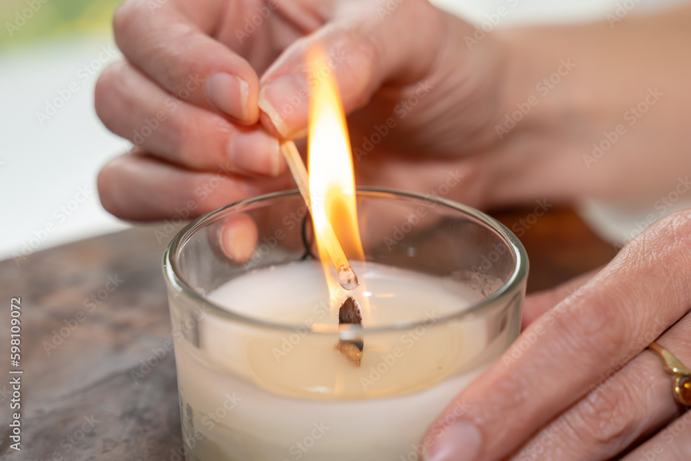 allumage d'une bougie parfumée avec une allumette sur une mèche en bois ...