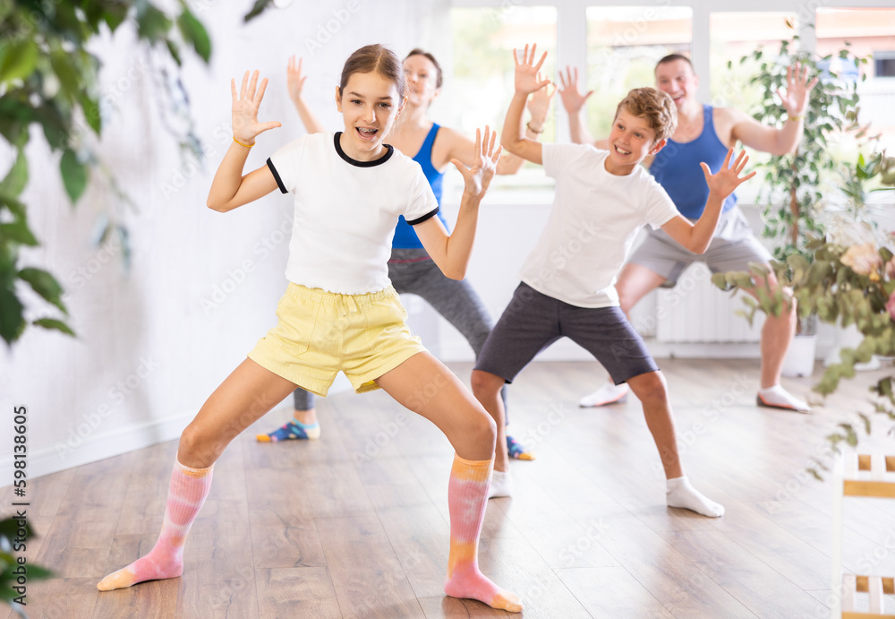 Joyful sister and brother practicing expressive dance movements against ...