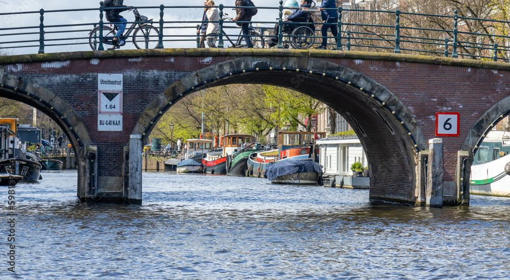 Amsterdam canals with arched bridges in the spring, dutch boat cruises ...