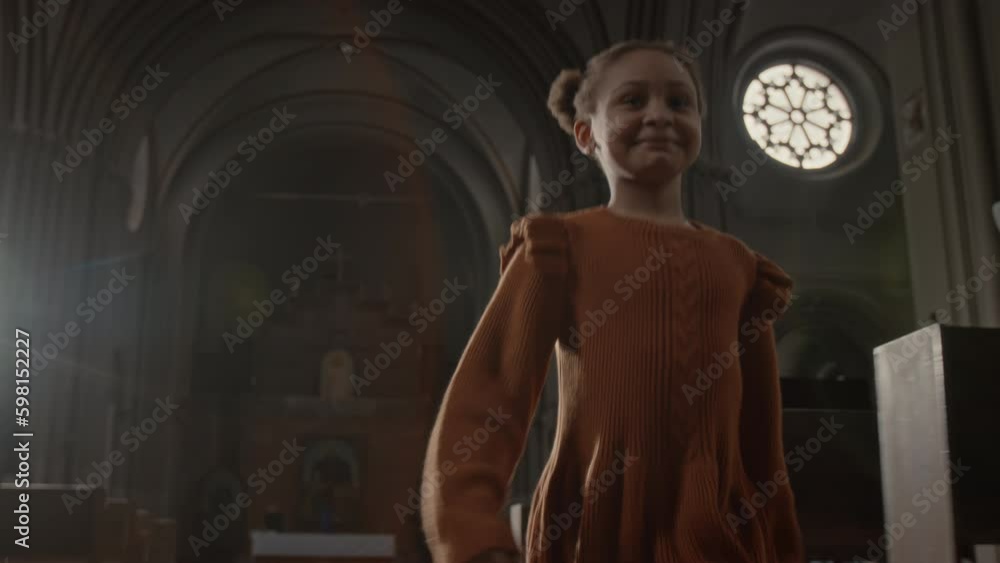 Medium slowmo of delighted African American girl running along nave in ...