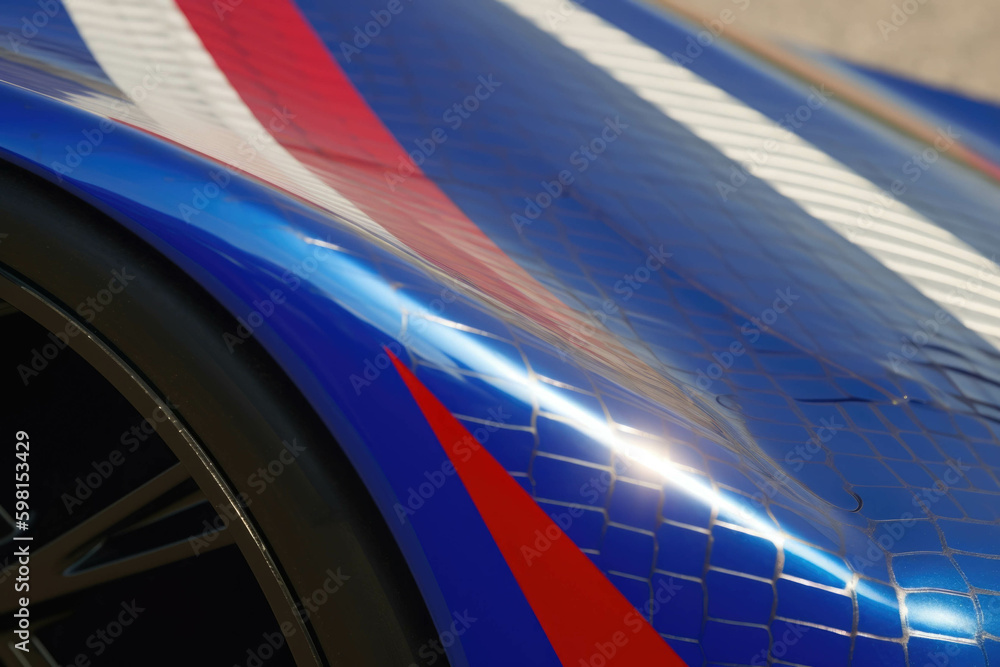 An intense zoom into a black and red racing car with a chrome accent ...