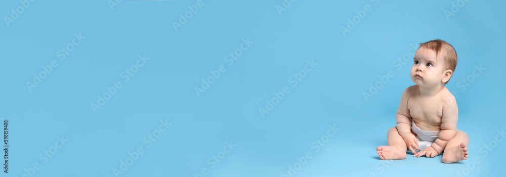 Cute baby in diaper sitting on light blue background, space for text ...