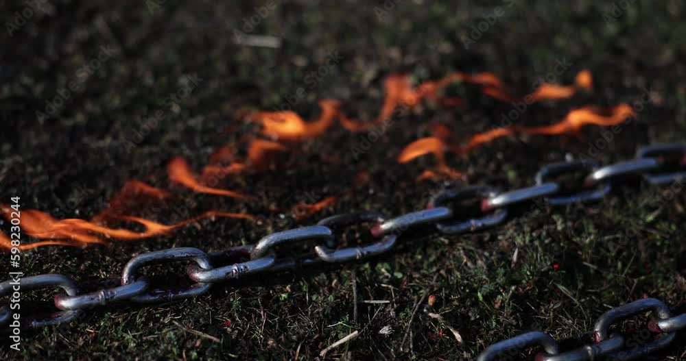 Galvanized rope battle chains for sport exercises lie on burning black ...