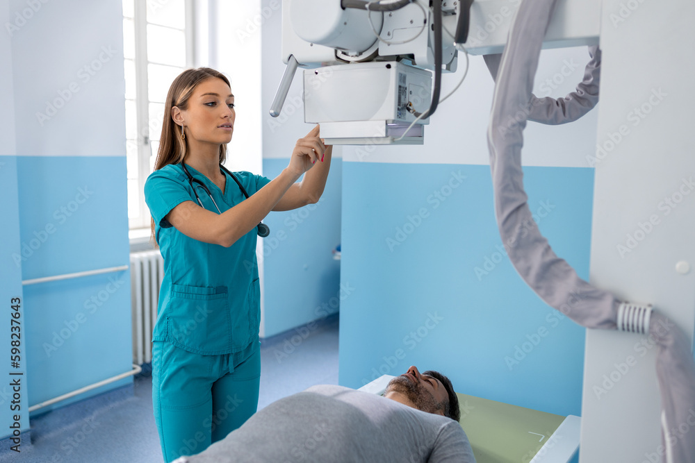 Female doctor sets up the machine to x-ray over patient. Radiologist ...