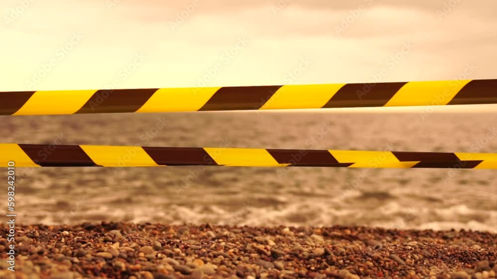 Yellow black warning tape barrier ribbon swinging in the wind across ...